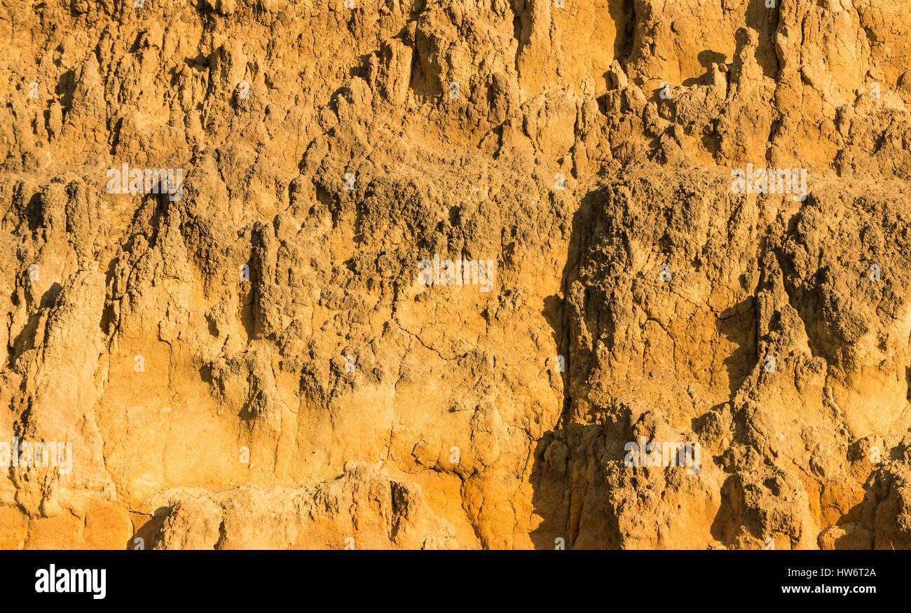 Golden colored dirt cliff looking very dry Stock Photo - Alamy