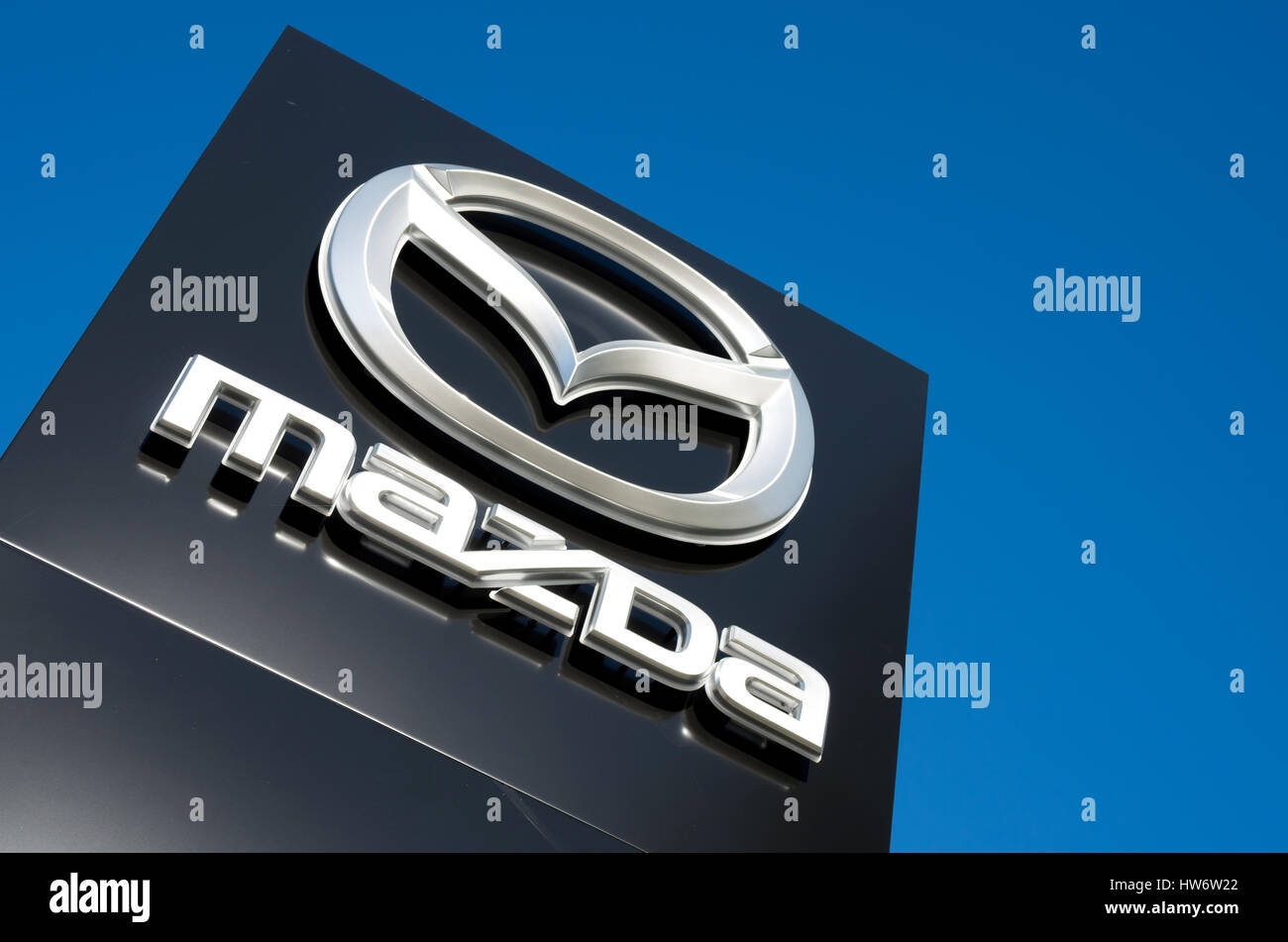 Mazda dealership sign against blue sky Stock Photo - Alamy