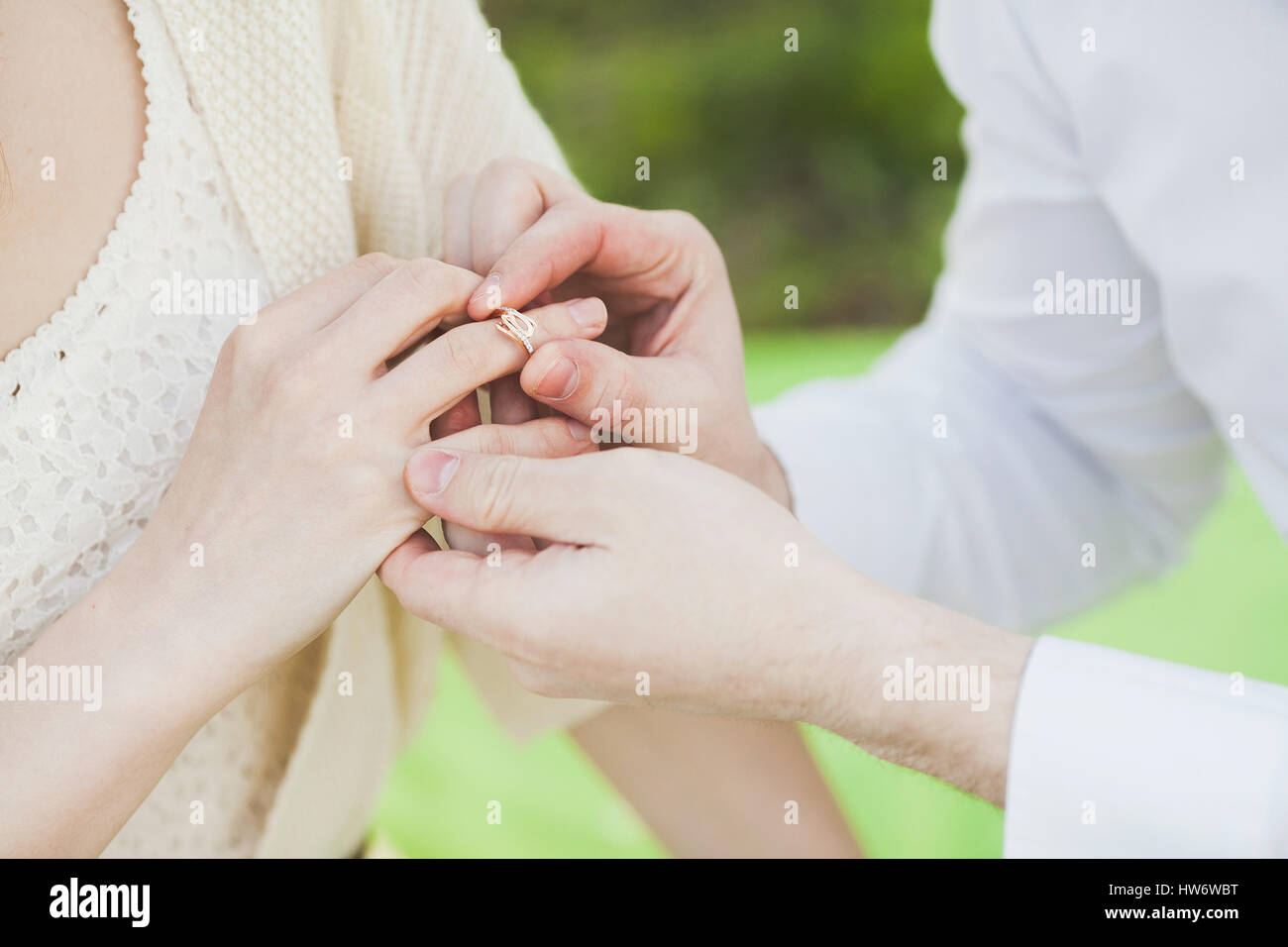 the offer to marry. hands of the man dressing a ring on the belo Stock ...