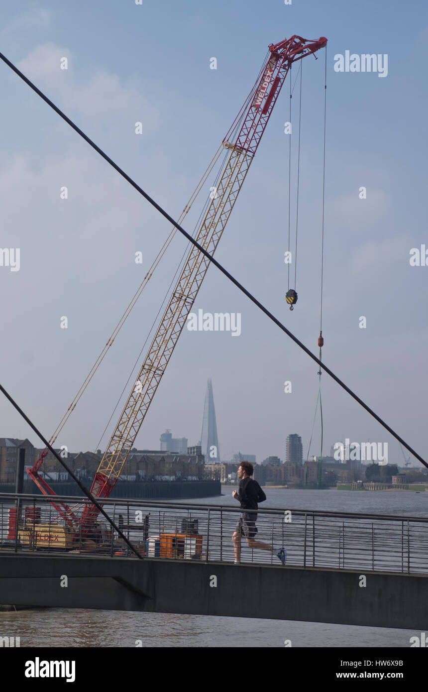 Maintenance dredging boat and cranes on river Thames by new office ...