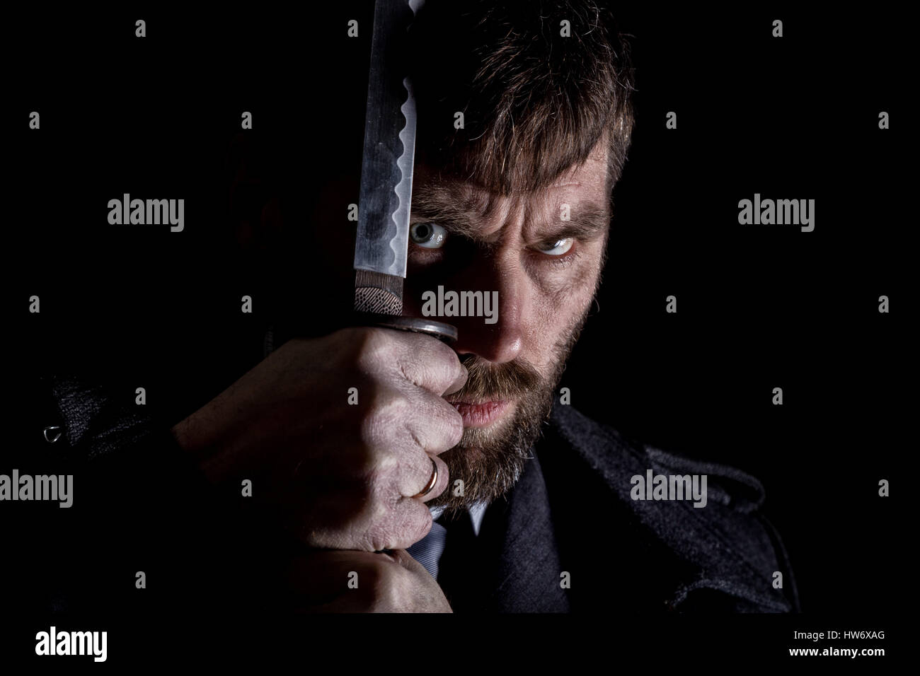 stern angry businessman in a wool coat with sword in dark background ...