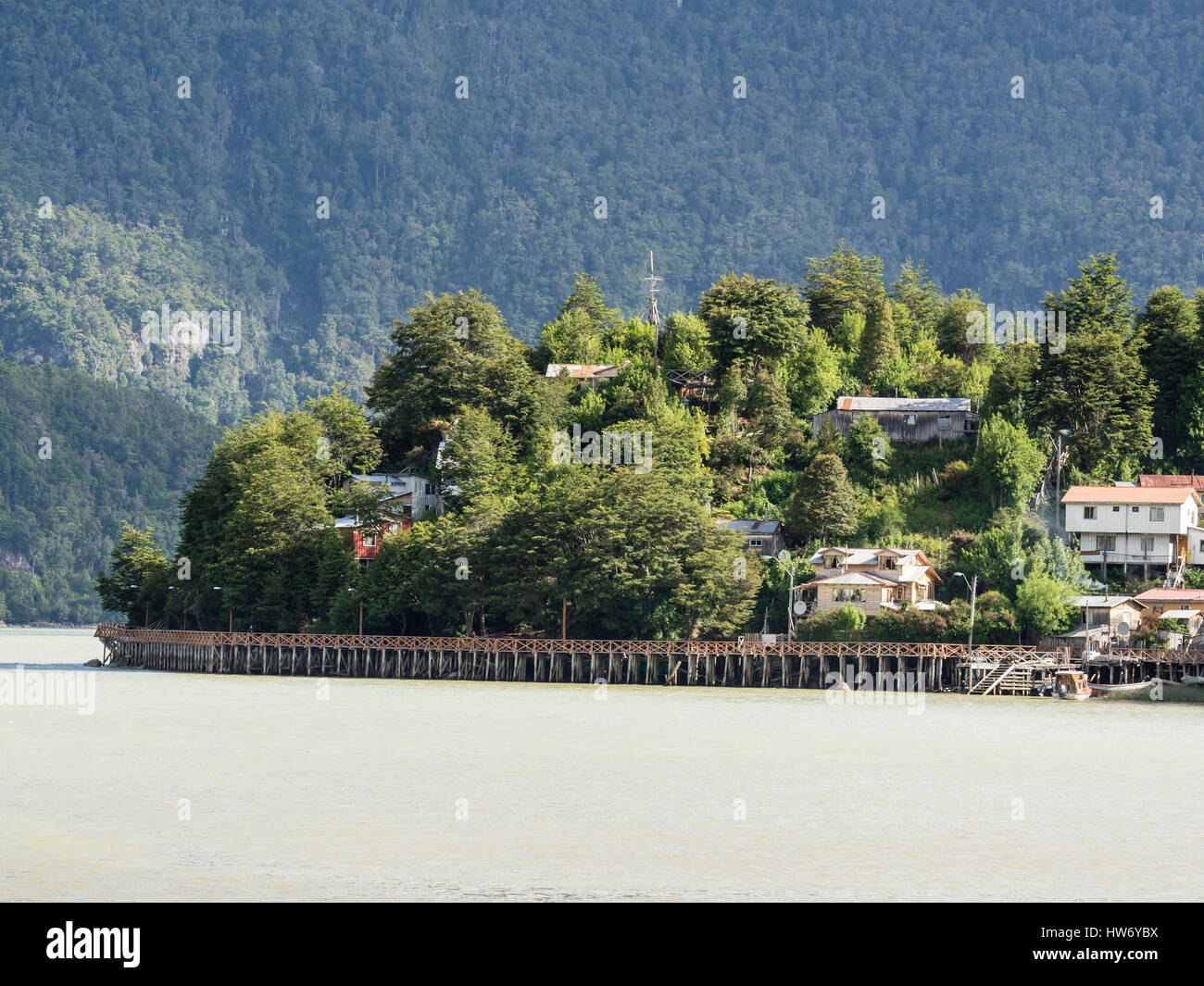 Houses and wooden boardwalk of Caleta Tortel right beside the sea ...
