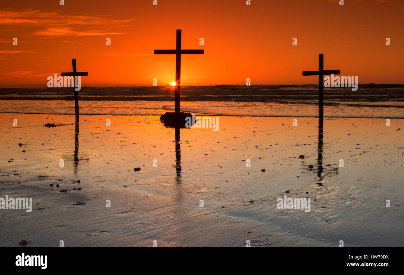 Three cross sunset at a beach with a hot looking sky Stock Photo - Alamy