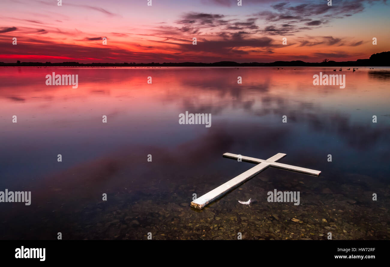 One white cross floating on a lake with a wonderful after sunset sky ...