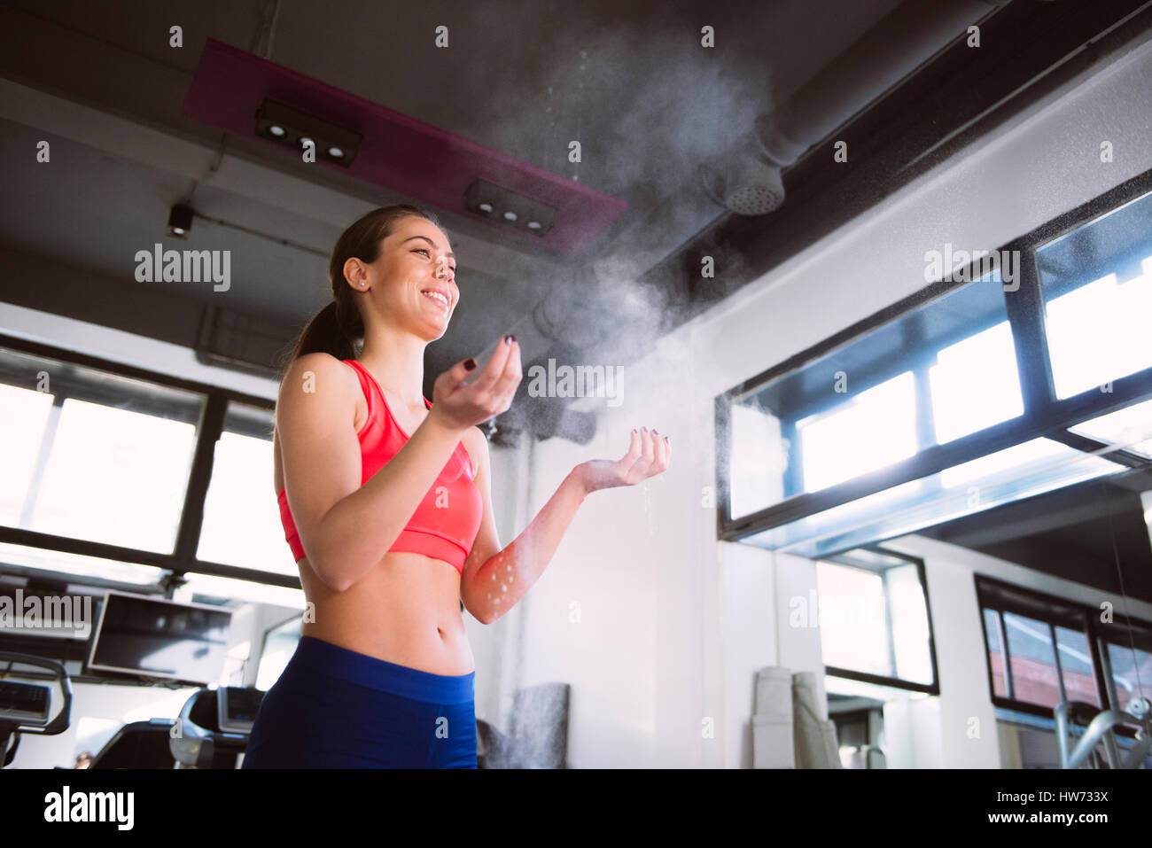 Young woman powder hands before exercise in the gym Stock Photo - Alamy