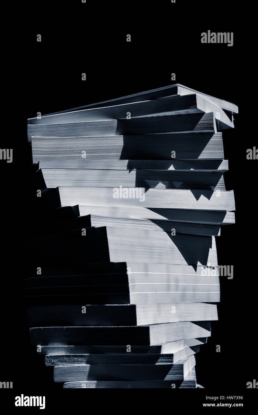 swirl of stacked books in black and white blue toned closeup Stock ...