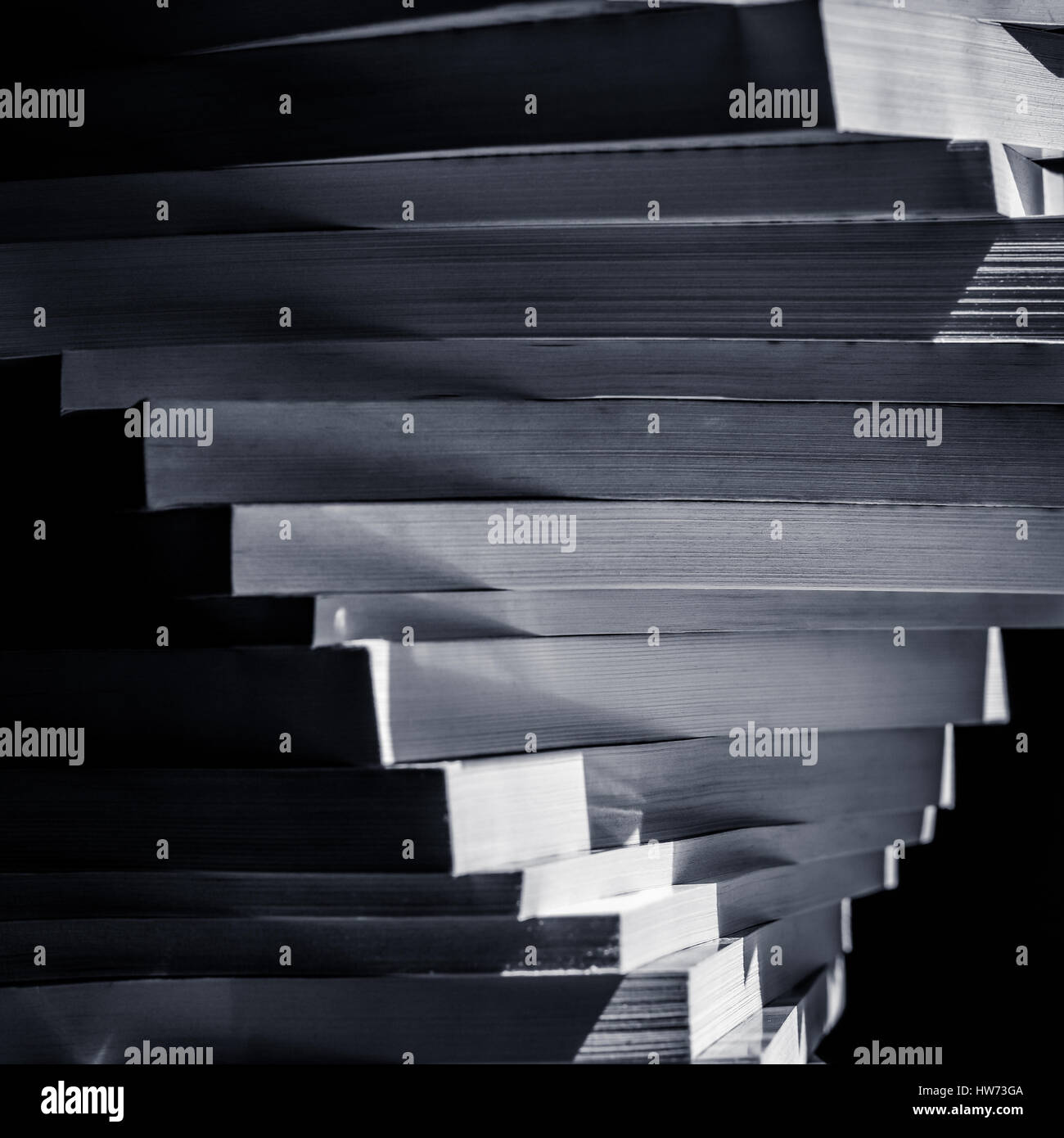 swirl of stacked books in black and white blue toned closeup Stock ...