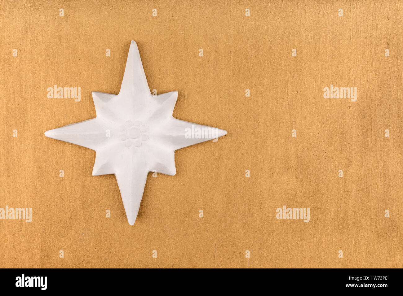 White Christmas star on gold background. View from above. Closeup Stock ...