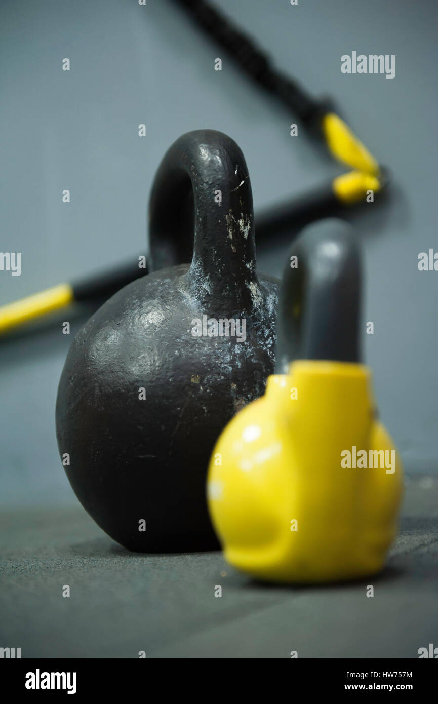 Different sizes of kettlebells weights lying on gym floor. Equipment ...
