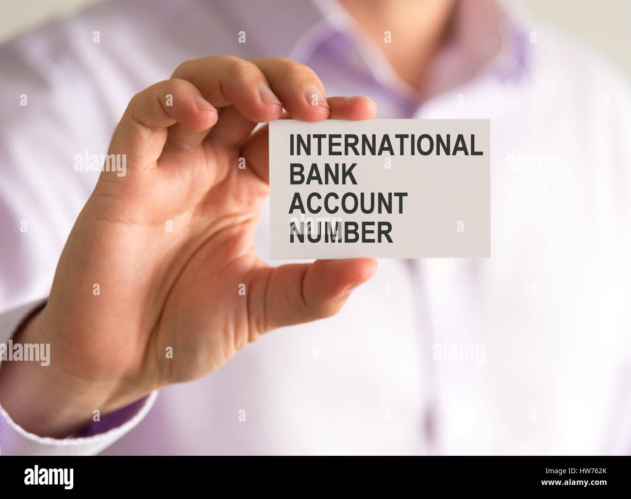 Closeup on businessman holding a card with IBAN INTERNATIONAL BANK ...