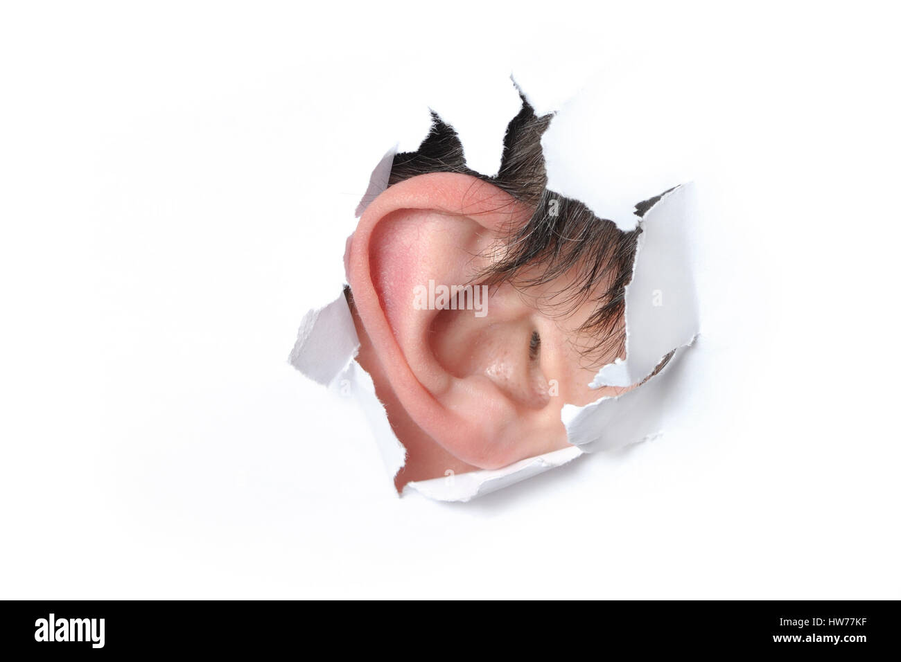 Ear in the hole of a paper Stock Photo - Alamy