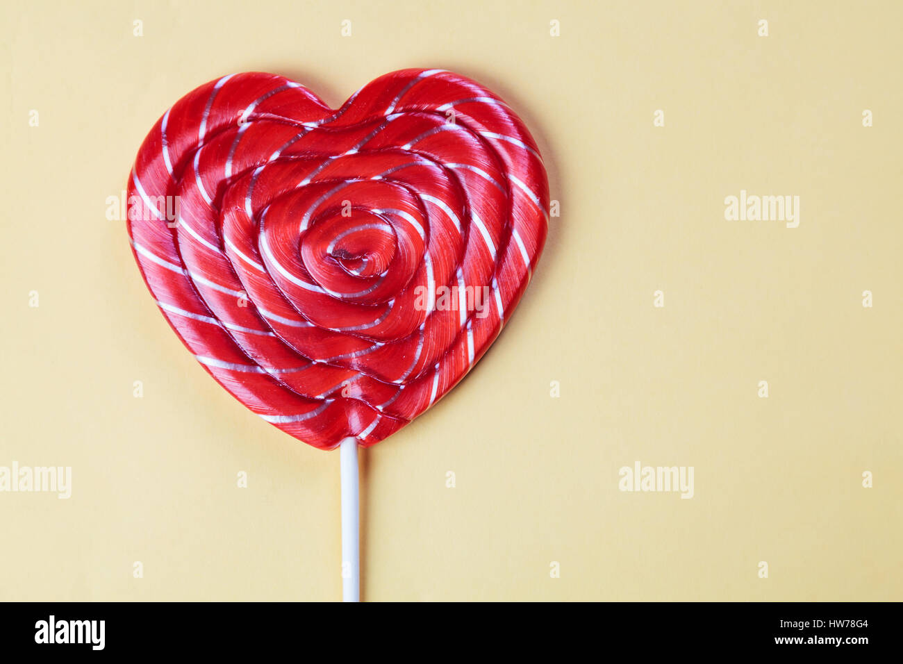 One candy heart shape on yellow background Stock Photo - Alamy