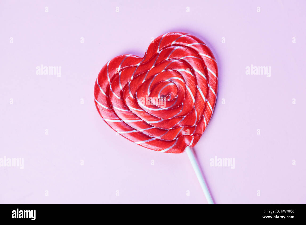 One candy heart shape on pink background Stock Photo - Alamy