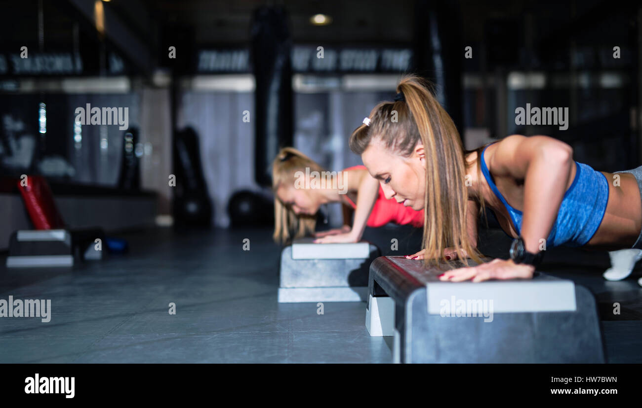 Two young athletic women doing push ups side view Stock Photo - Alamy