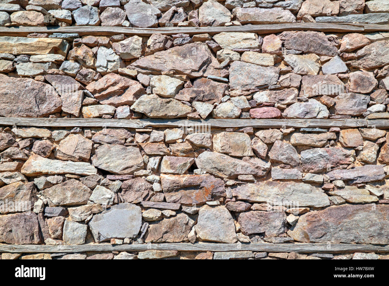 Stone wall background with wooden beams closeup Stock Photo - Alamy