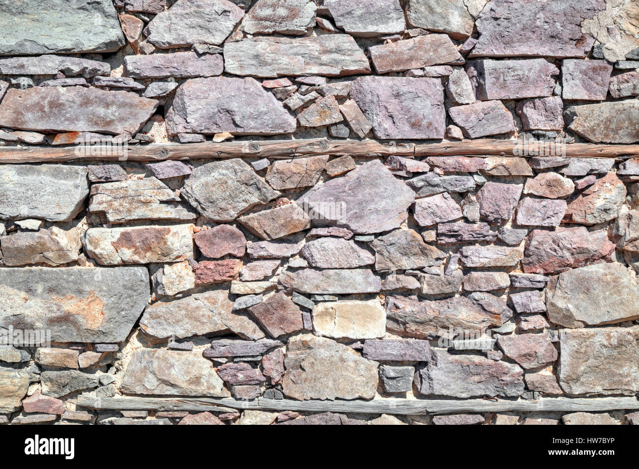 Stone wall background with wooden beams closeup Stock Photo - Alamy
