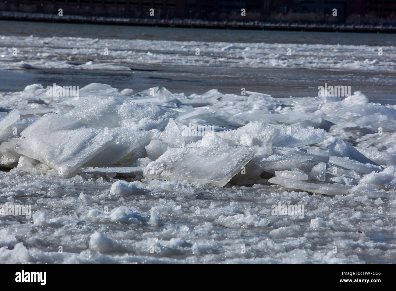 Frozen, snow capped ice blocks floating down the river on a cold winter ...