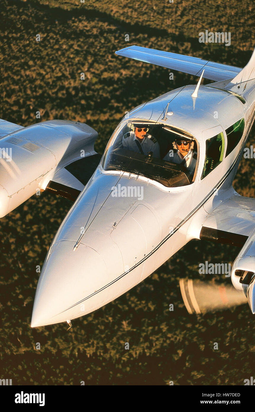 The setting sun illuminating a Cessna 310 aircraft in portrait view ...