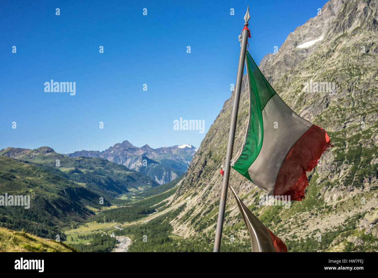 Italian flag high in the Alps overlooking a valley Stock Photo - Alamy