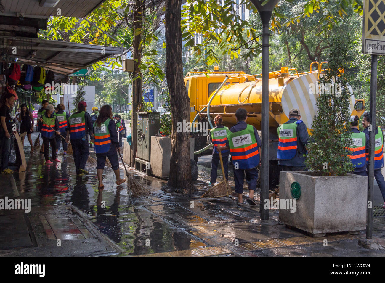 Street cleaners washing the pavements during the early morning in ...