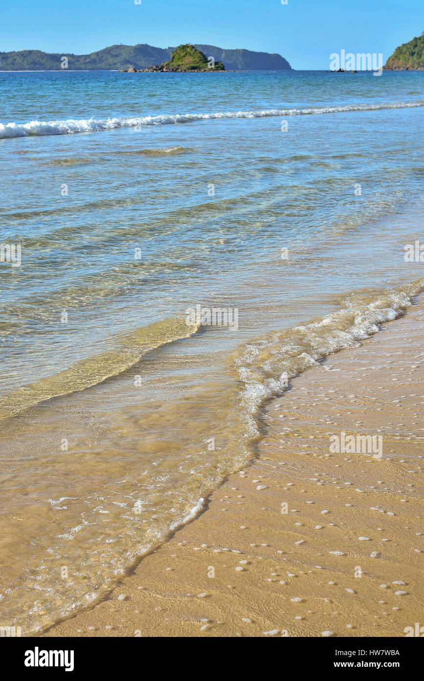 Small tropical islands sat on the horizon taken across an empty beach ...
