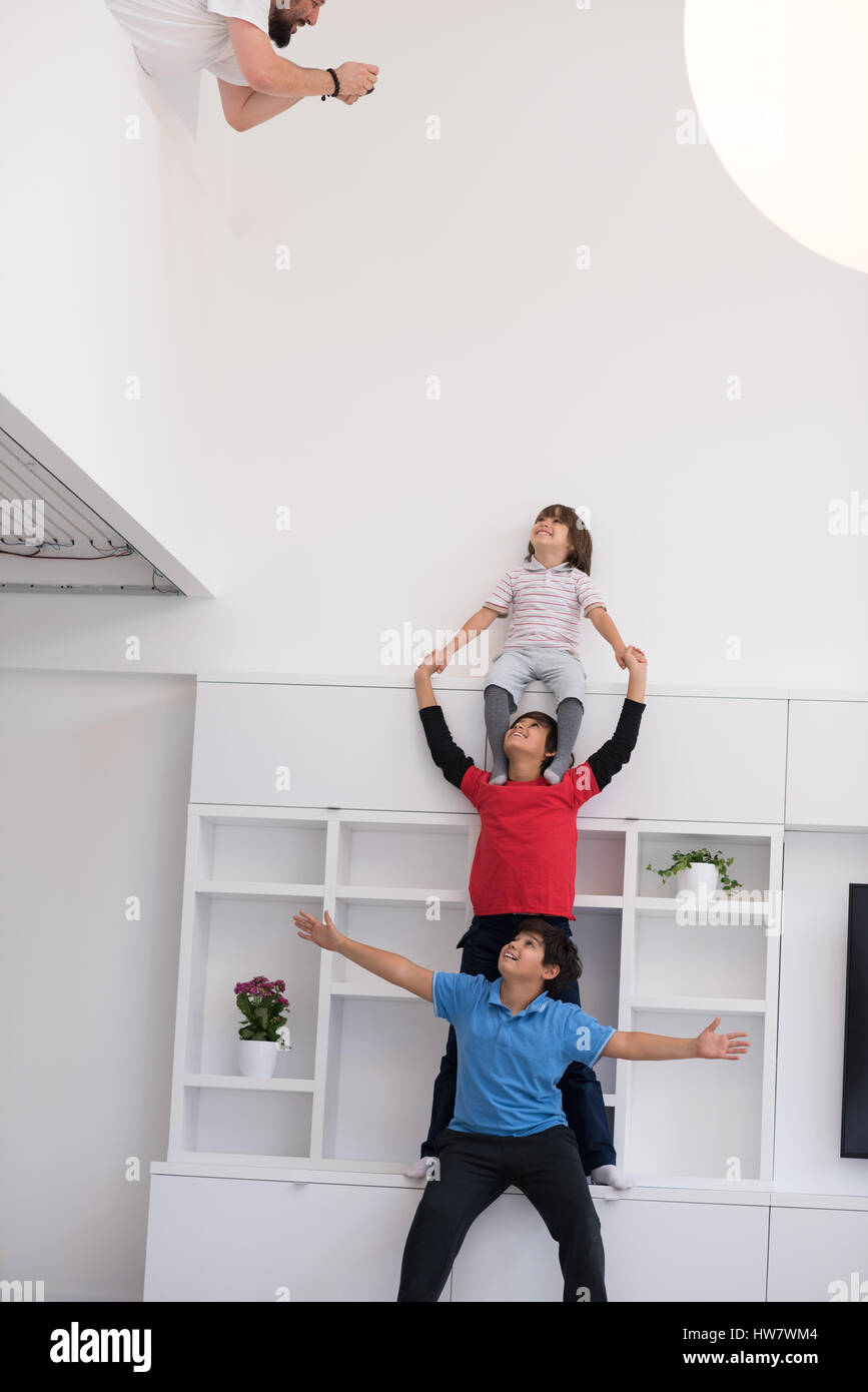happy young boys having fun and posing line up piggyback in new modern ...