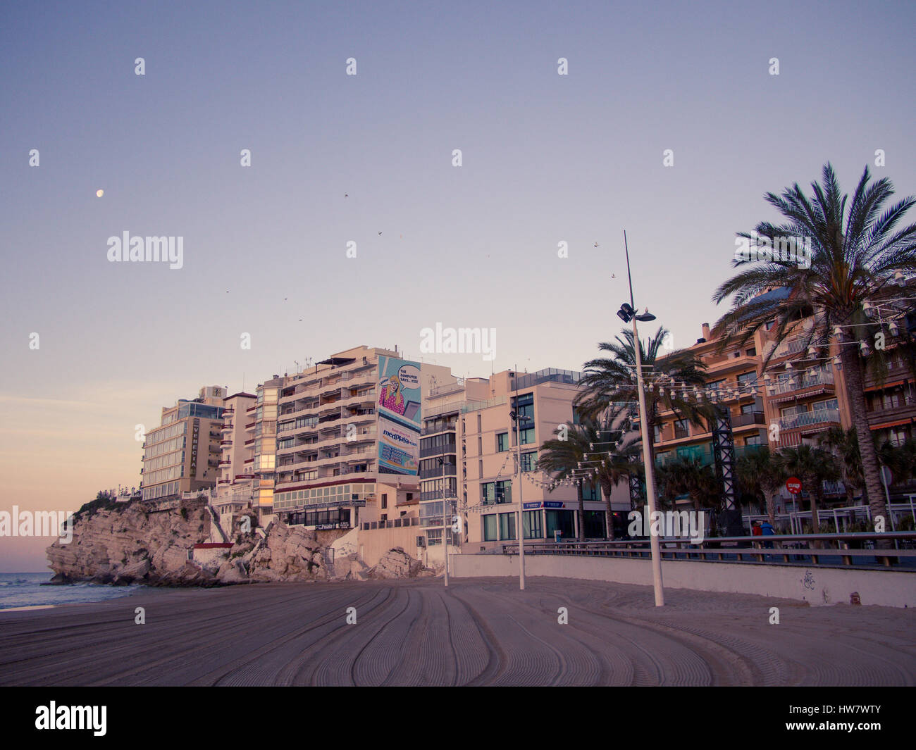 The moon sits low above Benidorm Old Town at dawn Stock Photo - Alamy