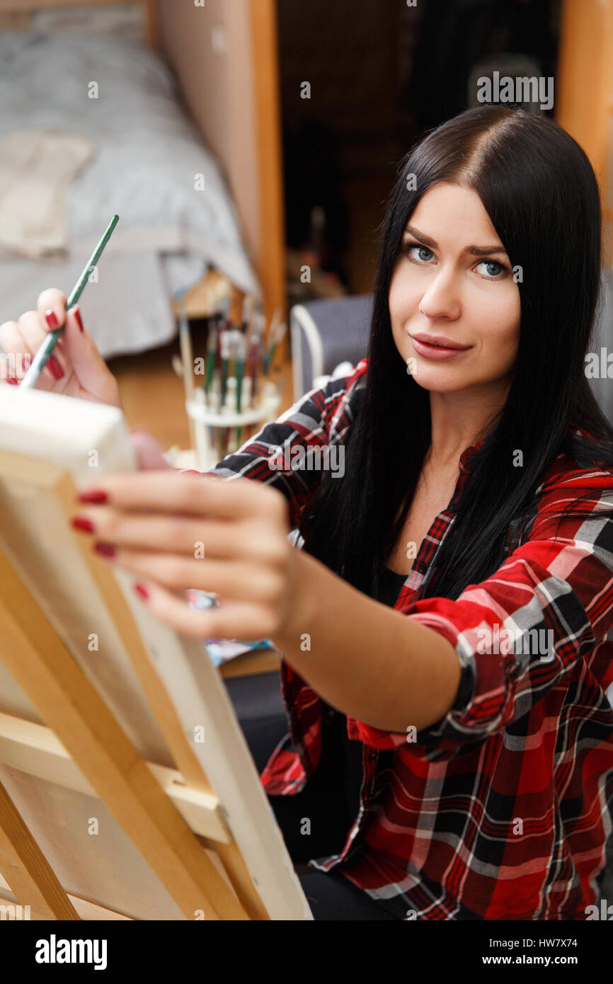 Beautiful long-haired painter at easel Stock Photo - Alamy