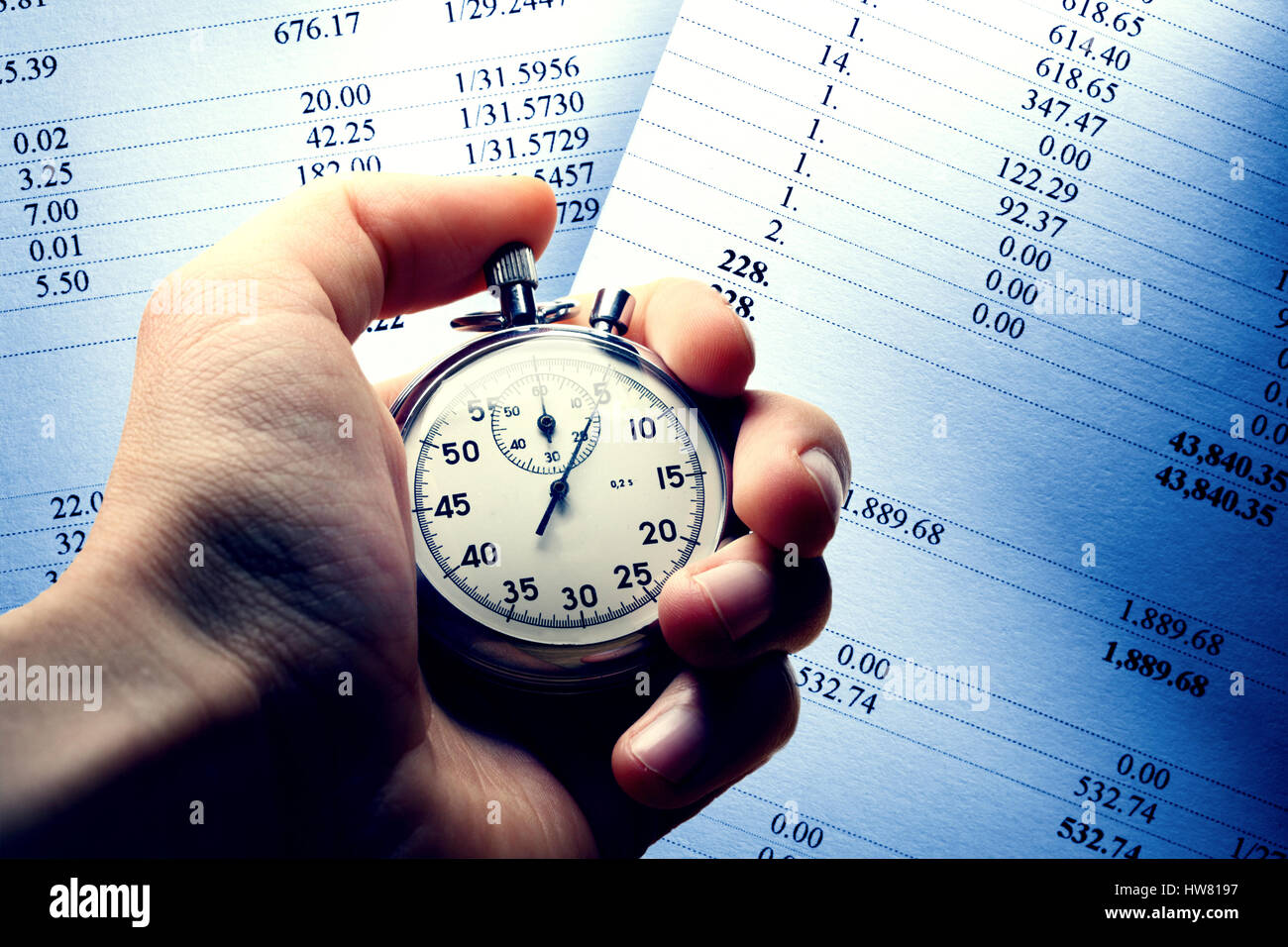 Hand holding stopwatch on budget numbers in closeup Stock Photo - Alamy
