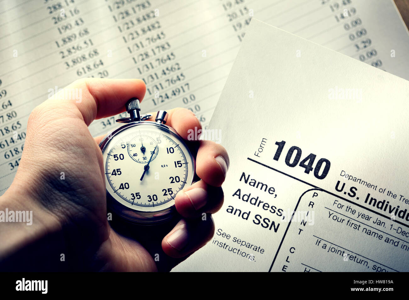 Hand holding stopwatch on budget numbers in closeup Stock Photo - Alamy