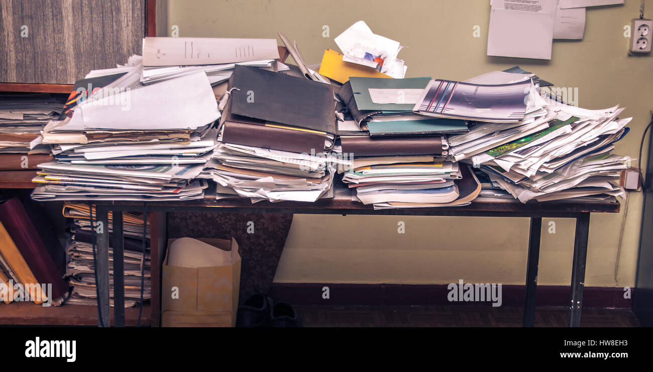 Messy workplace with stack of old papers Stock Photo - Alamy