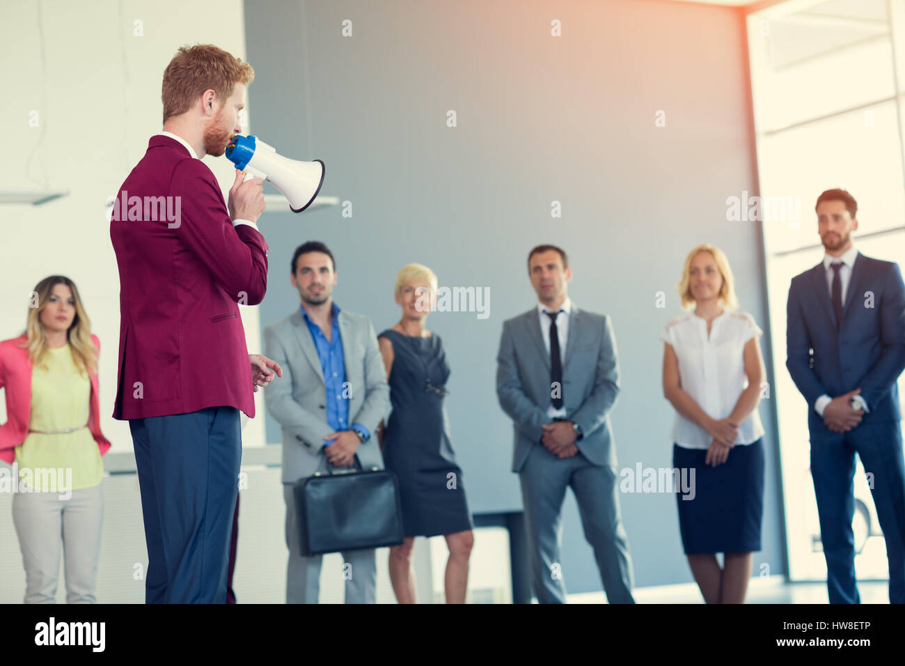 leader with megaphone talking his business team of successful dealing ...