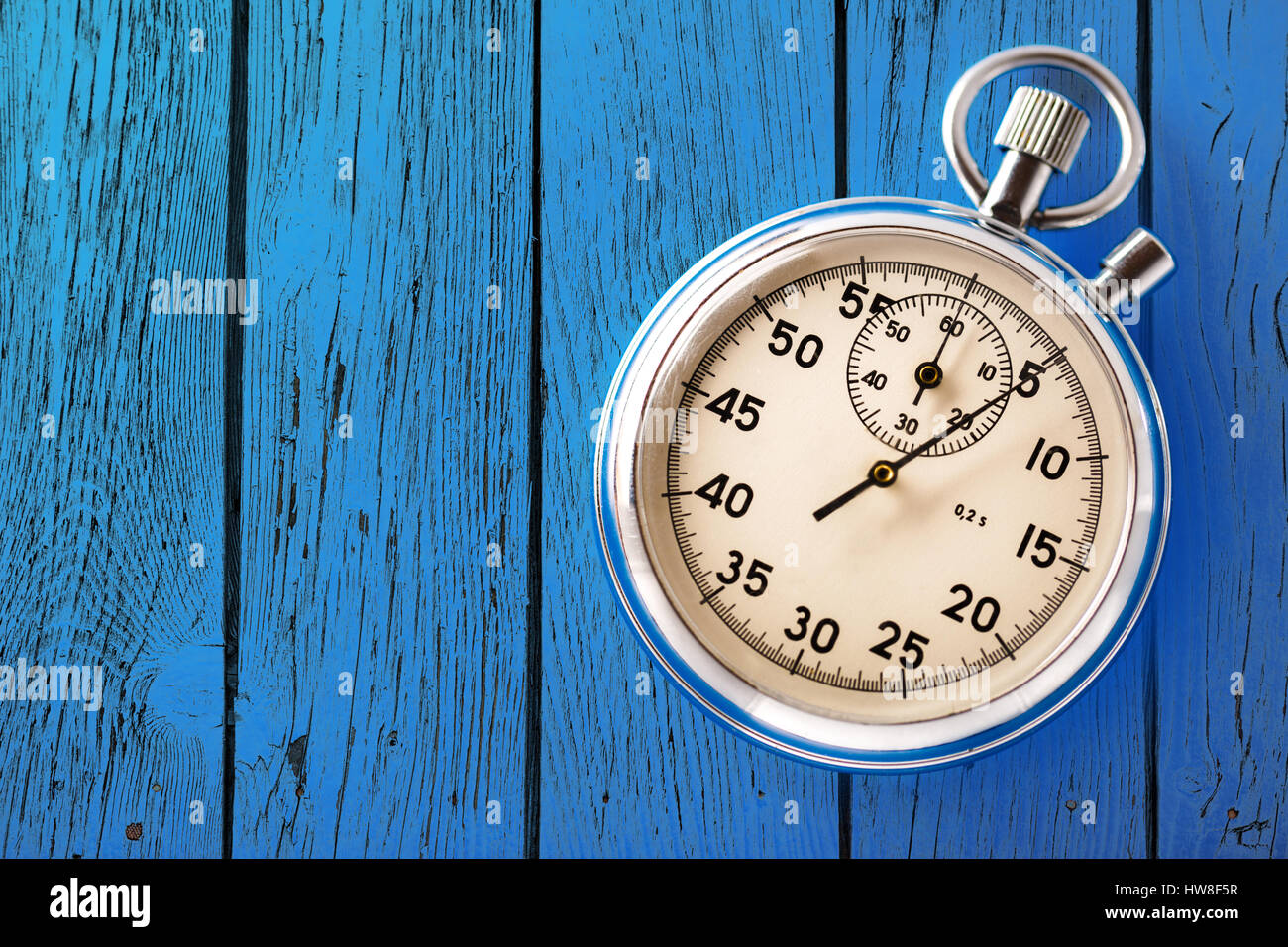 Stopwatch on blue background in closeup Stock Photo - Alamy