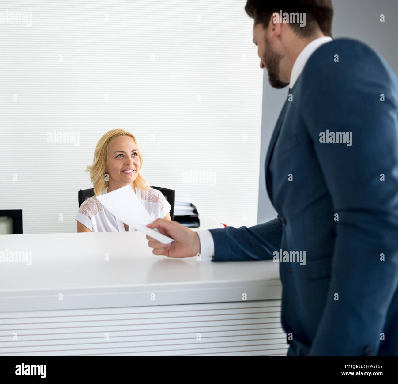 Female receptionist attending handsome passenger Stock Photo - Alamy