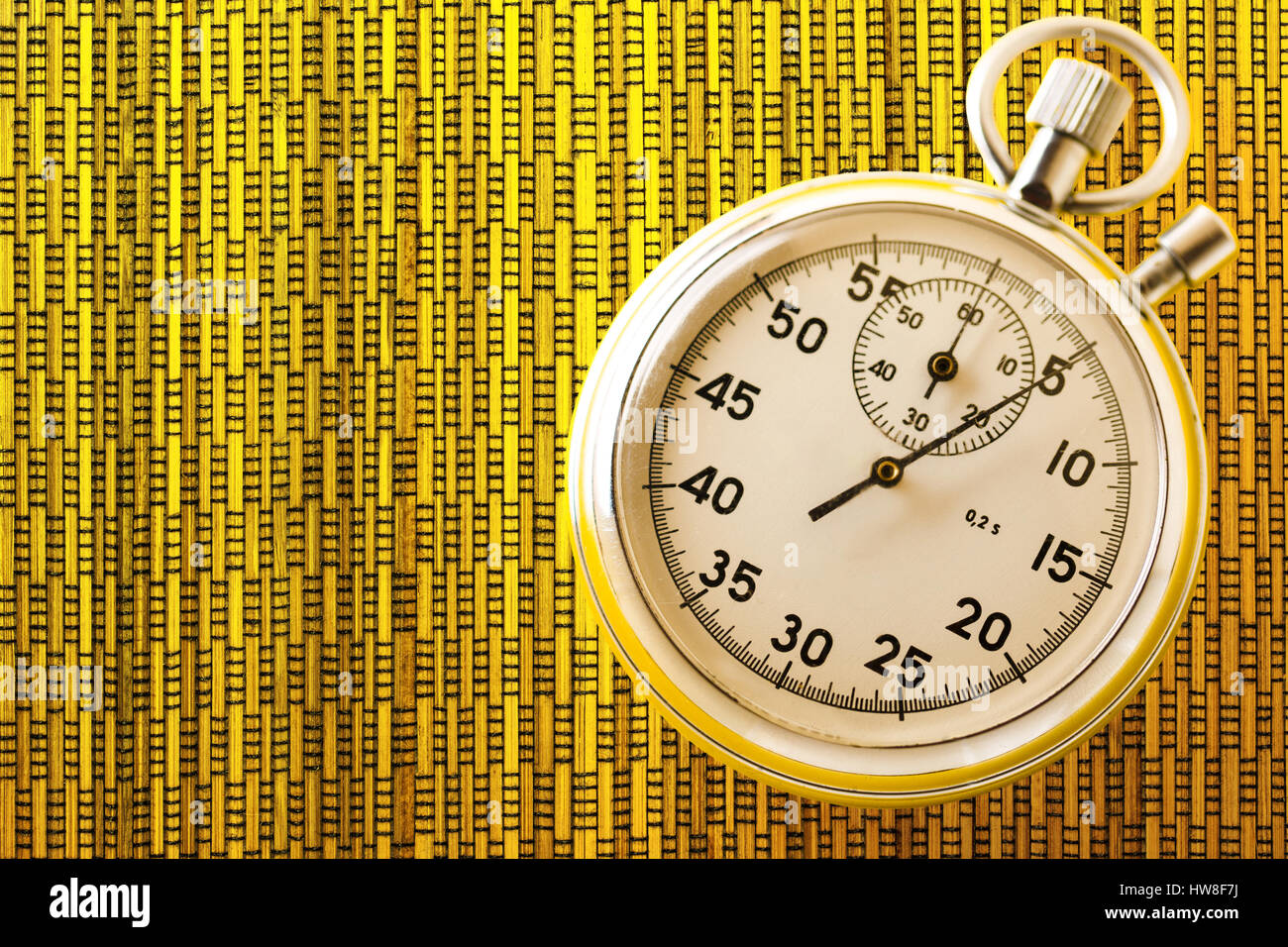 Stopwatch on yellow background in closeup Stock Photo - Alamy