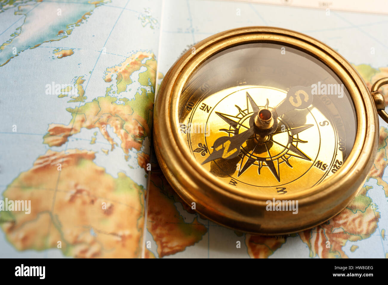 Metal compass on map background in closeup Stock Photo - Alamy