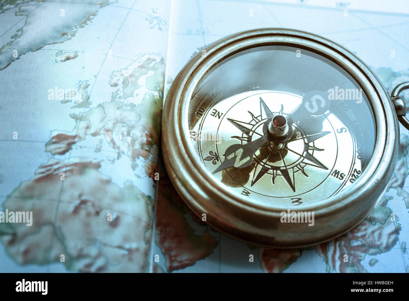 Compass on map background in blue toning Stock Photo - Alamy