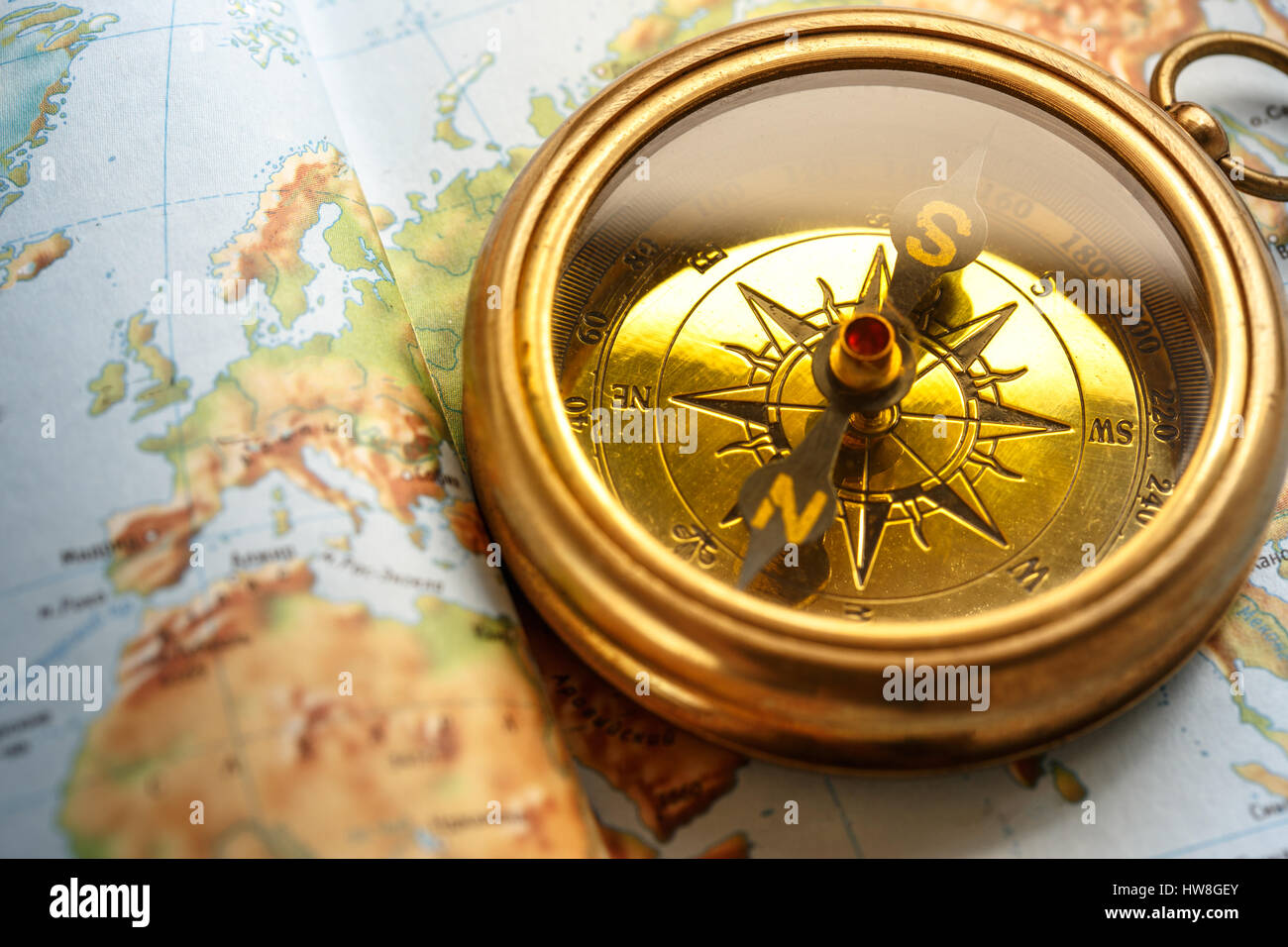 Metal compass on map background in closeup Stock Photo - Alamy