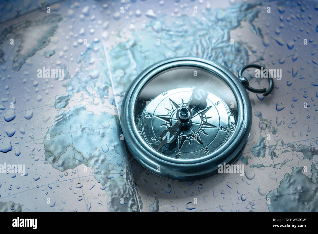 Compass on map background in blue toning Stock Photo - Alamy
