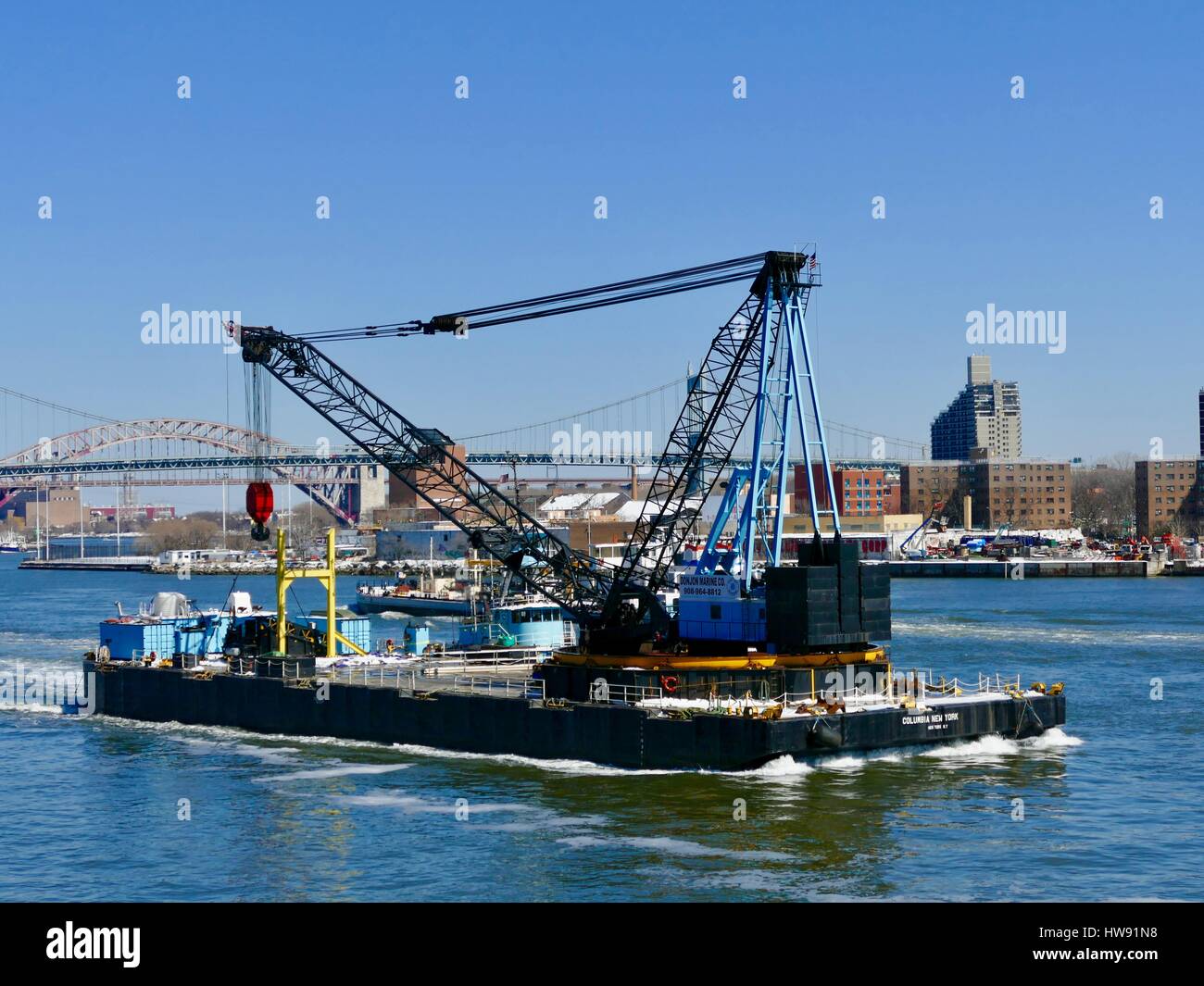 Commercial barge with crane, light blue trim, heading down the East ...