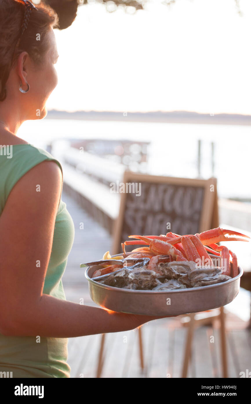 Woman holding seafood plate hi-res stock photography and images - Alamy