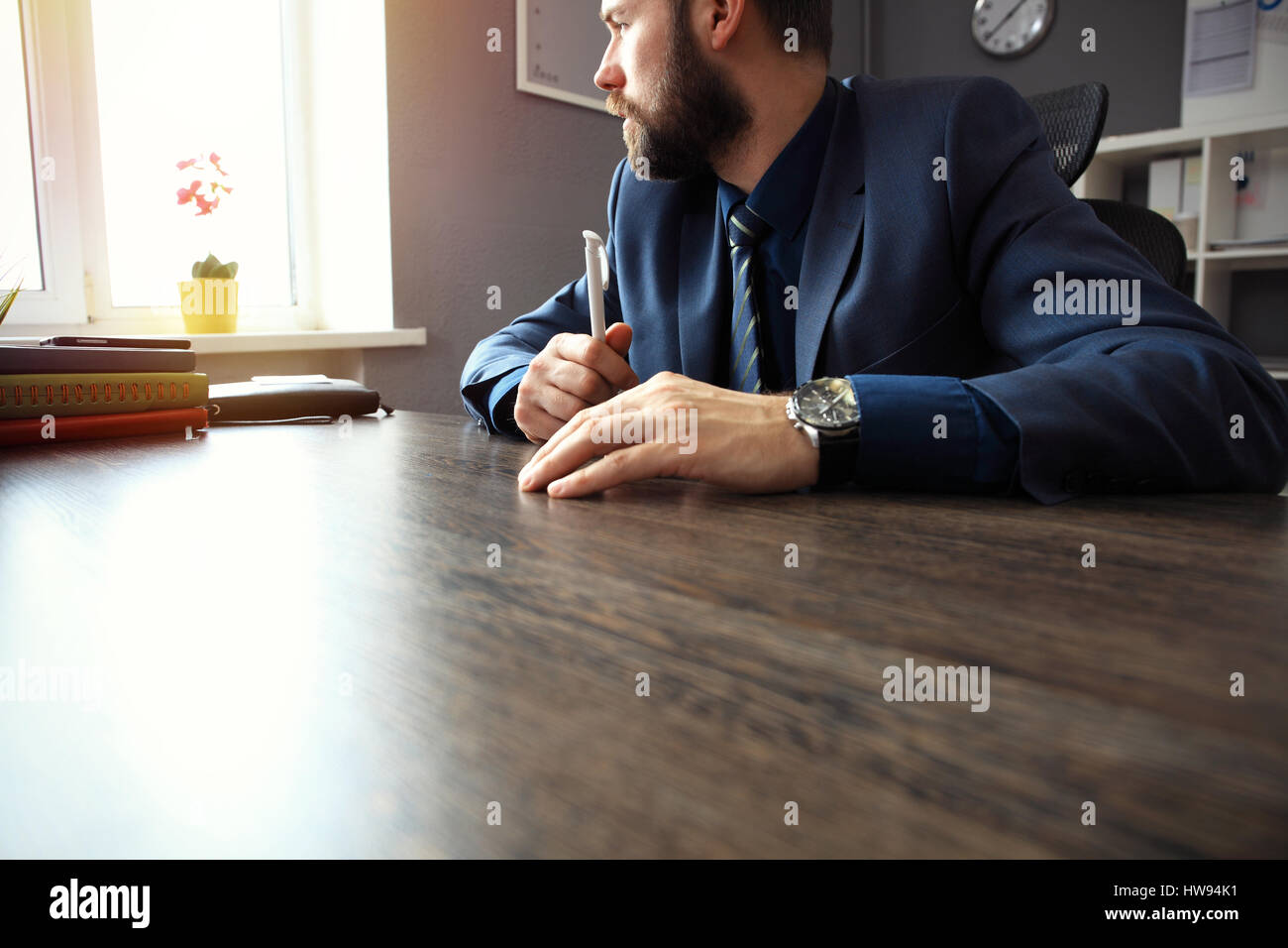 Portrait of young man sitting at his desk in the office Stock Photo - Alamy