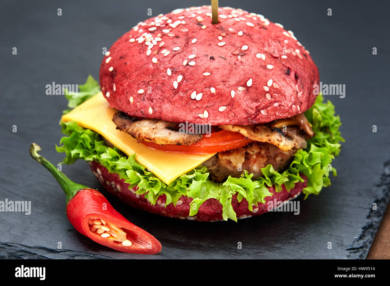 Red hamburger with chili on stone table with black background. Fastfood ...