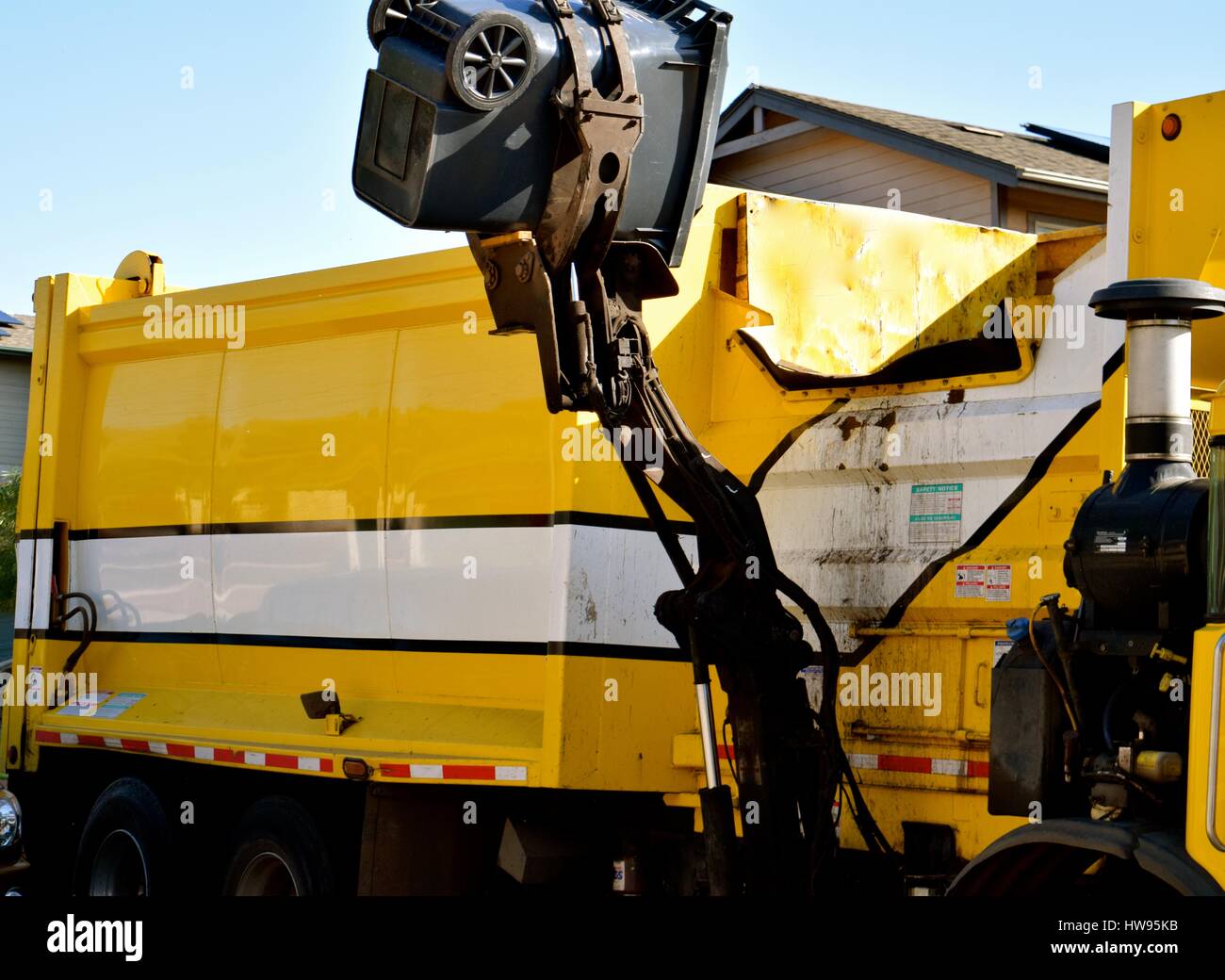 Mechanical lifting arm grabbing the trash bin to dispose of its ...