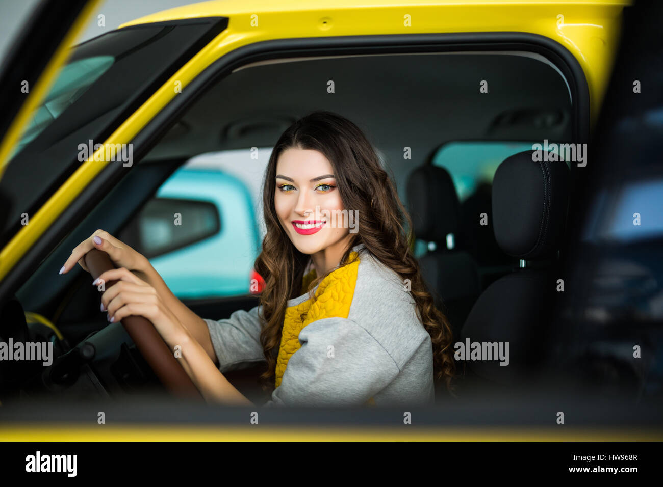 Cute young lady happy driving yellow car Stock Photo - Alamy