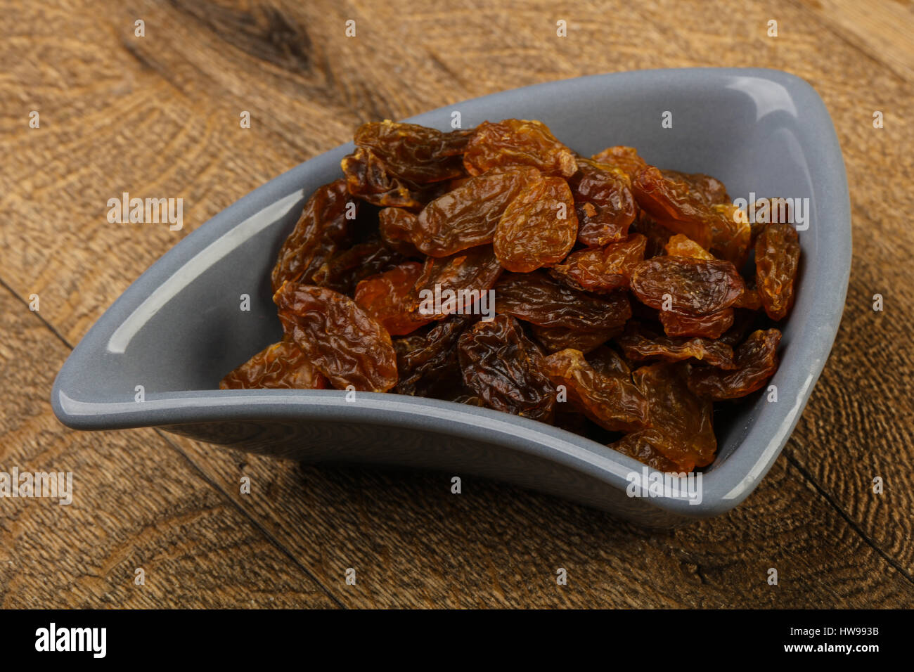 Dry Raisin in the bowl over the wooden background Stock Photo - Alamy