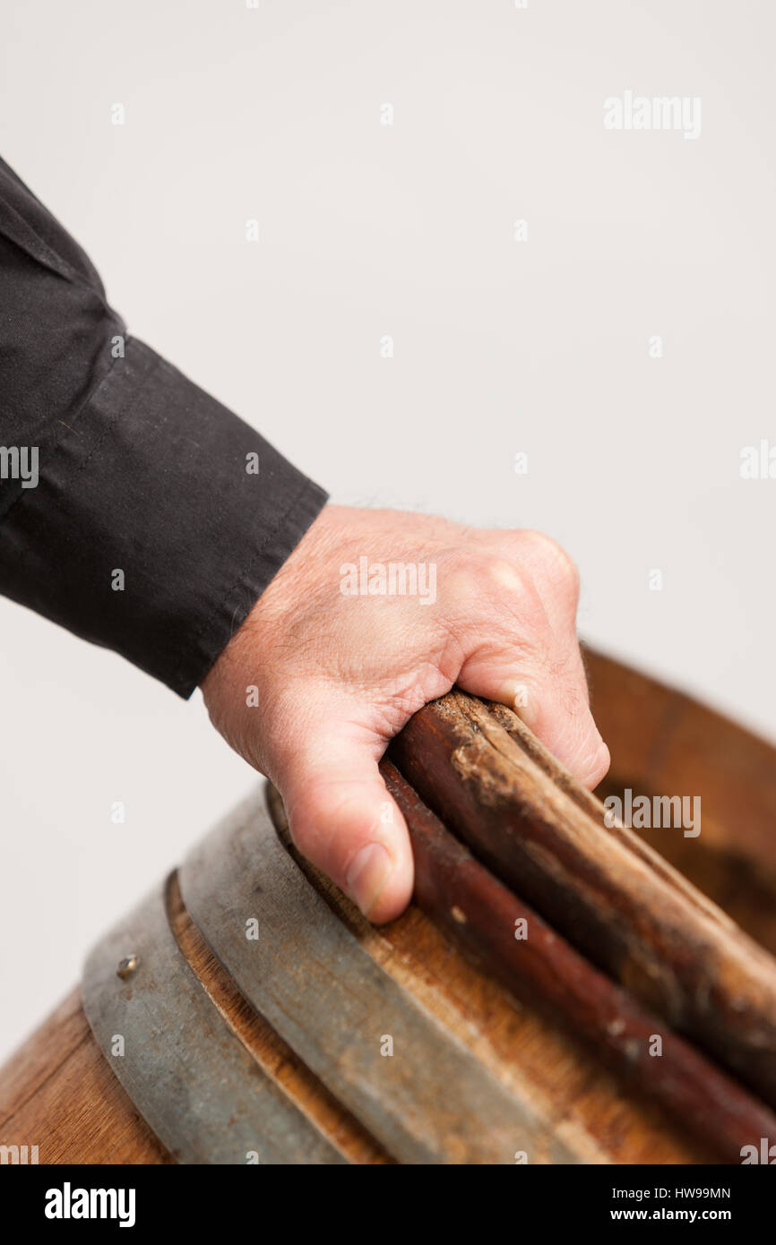 Male hand holding old wooden barrel edge, close-up over white ...