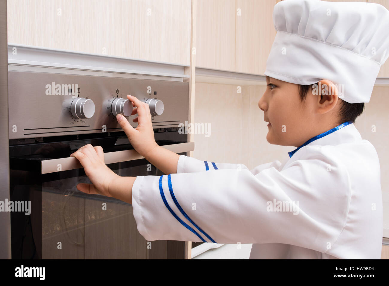 Asian Chinese Boy in white chef uniform Baking Cookies at Home Stock ...