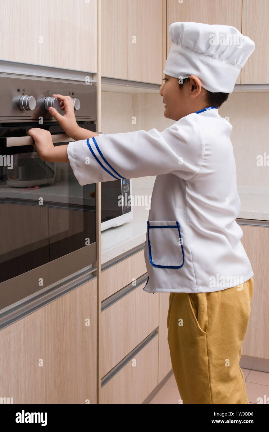 Asian Chinese Boy in white chef uniform Baking Cookies at Home Stock ...