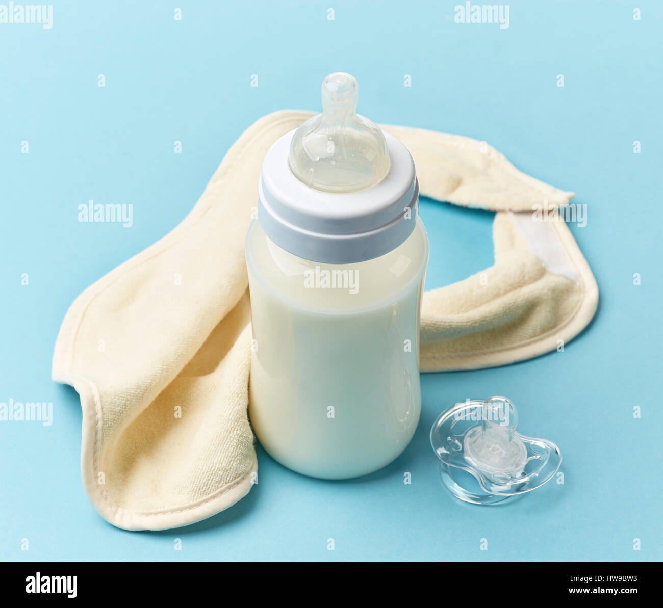 baby milk bottle and pacifier on blue background Stock Photo - Alamy